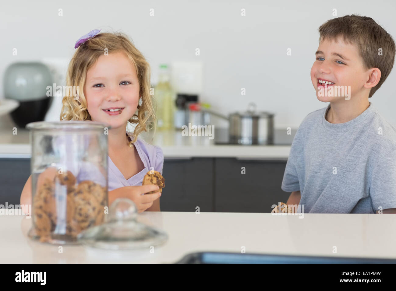 Brother and sister having cookies Stock Photo - Alamy