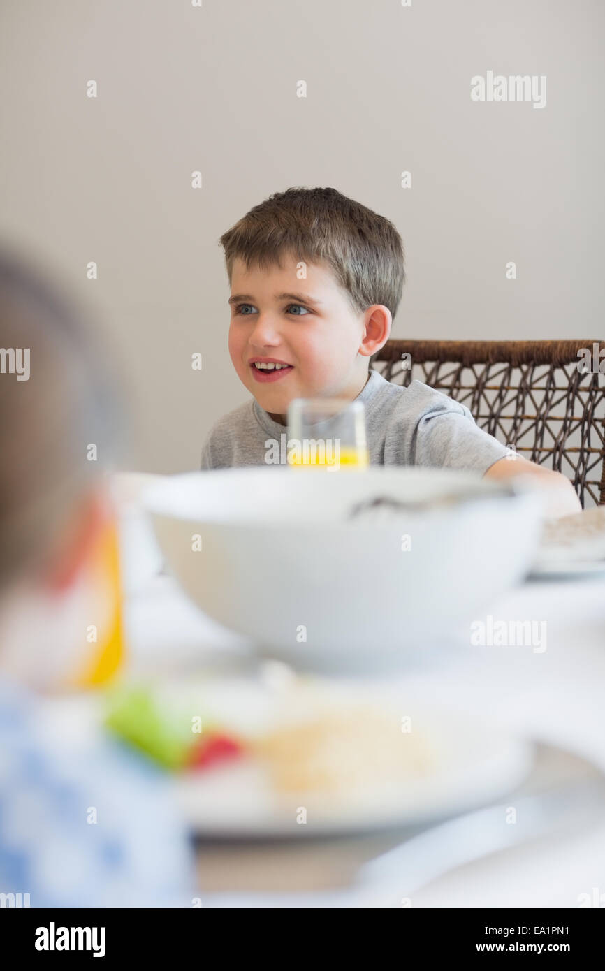 Boy looking away at breakfast table Stock Photo - Alamy