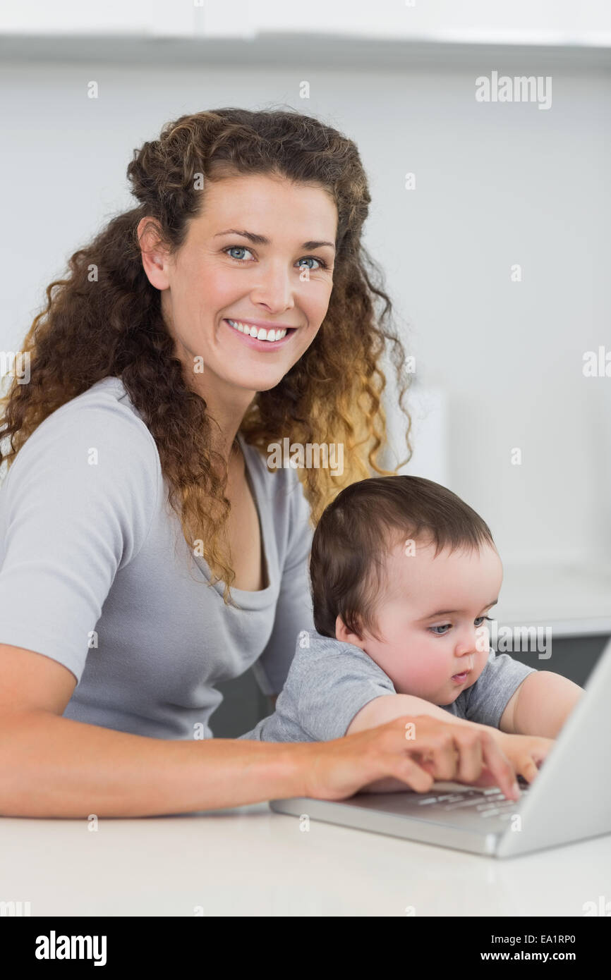 Woman with baby using laptop Stock Photo - Alamy