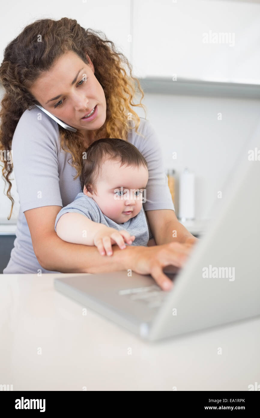 Mother multi tasking at home Stock Photo - Alamy