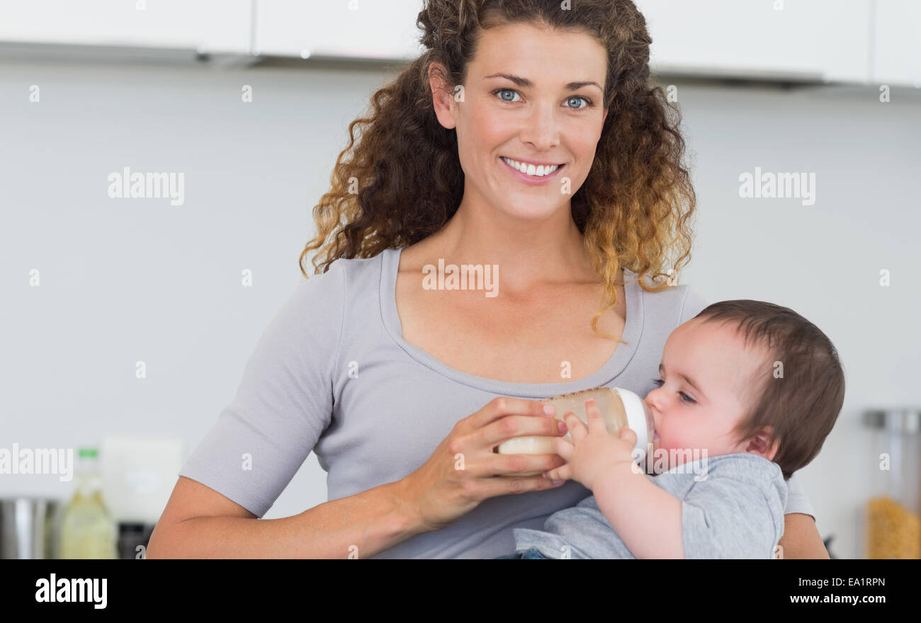 Attractive woman feeding milk to baby Stock Photo - Alamy