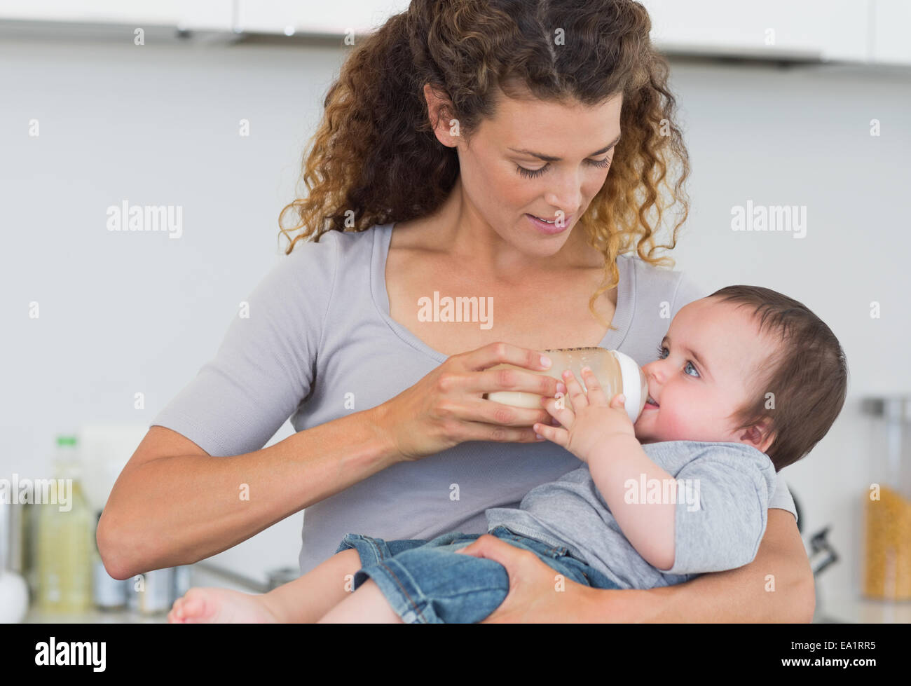 Beautiful mother feeding milk to baby Stock Photo - Alamy