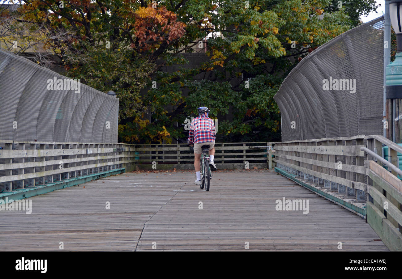 An older man on a bicycle crossing an overpass over the Clearview ...