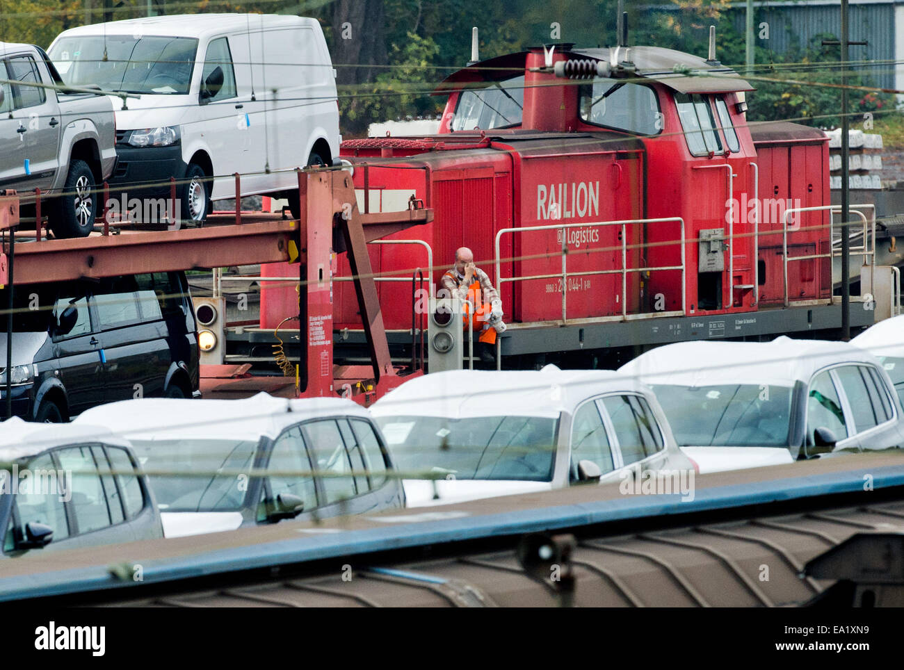 A staff member of the Deutsche Bahn (DB) climbs onto a diesel train ...