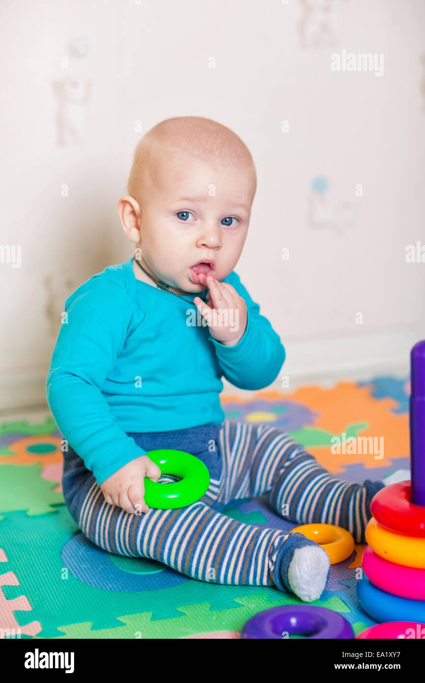 Cute little baby playing with colorful toys at home Stock Photo - Alamy