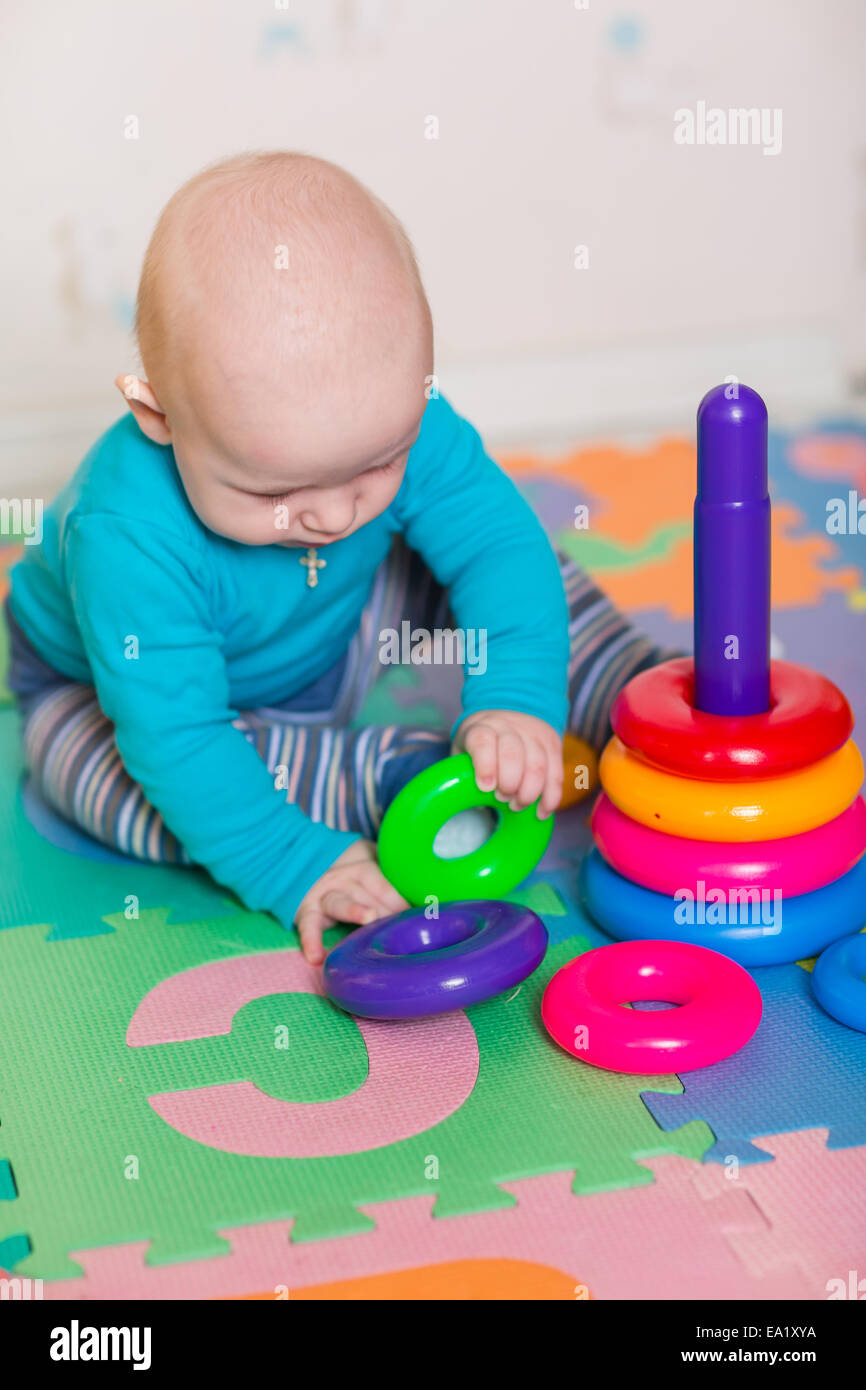 Cute little baby playing with colorful toys at home Stock Photo - Alamy