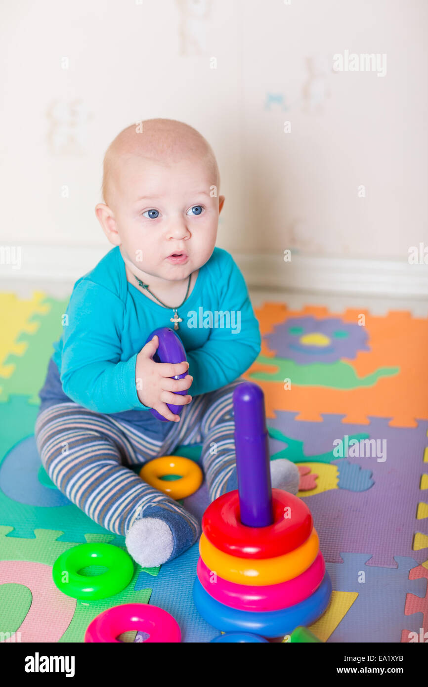 Cute little baby playing with colorful toys at home Stock Photo - Alamy
