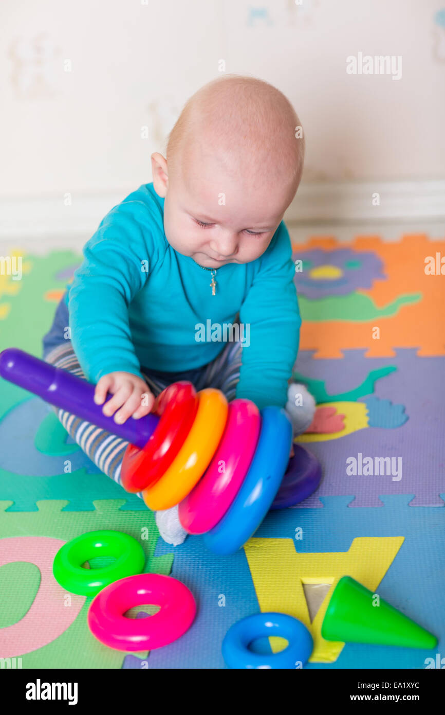 Cute little baby playing with colorful toys at home Stock Photo - Alamy