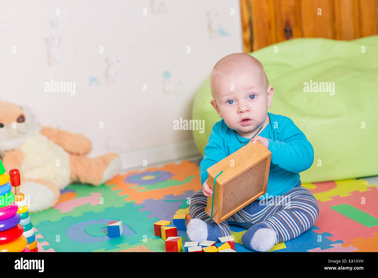 Cute little baby playing with colorful toys at home Stock Photo - Alamy
