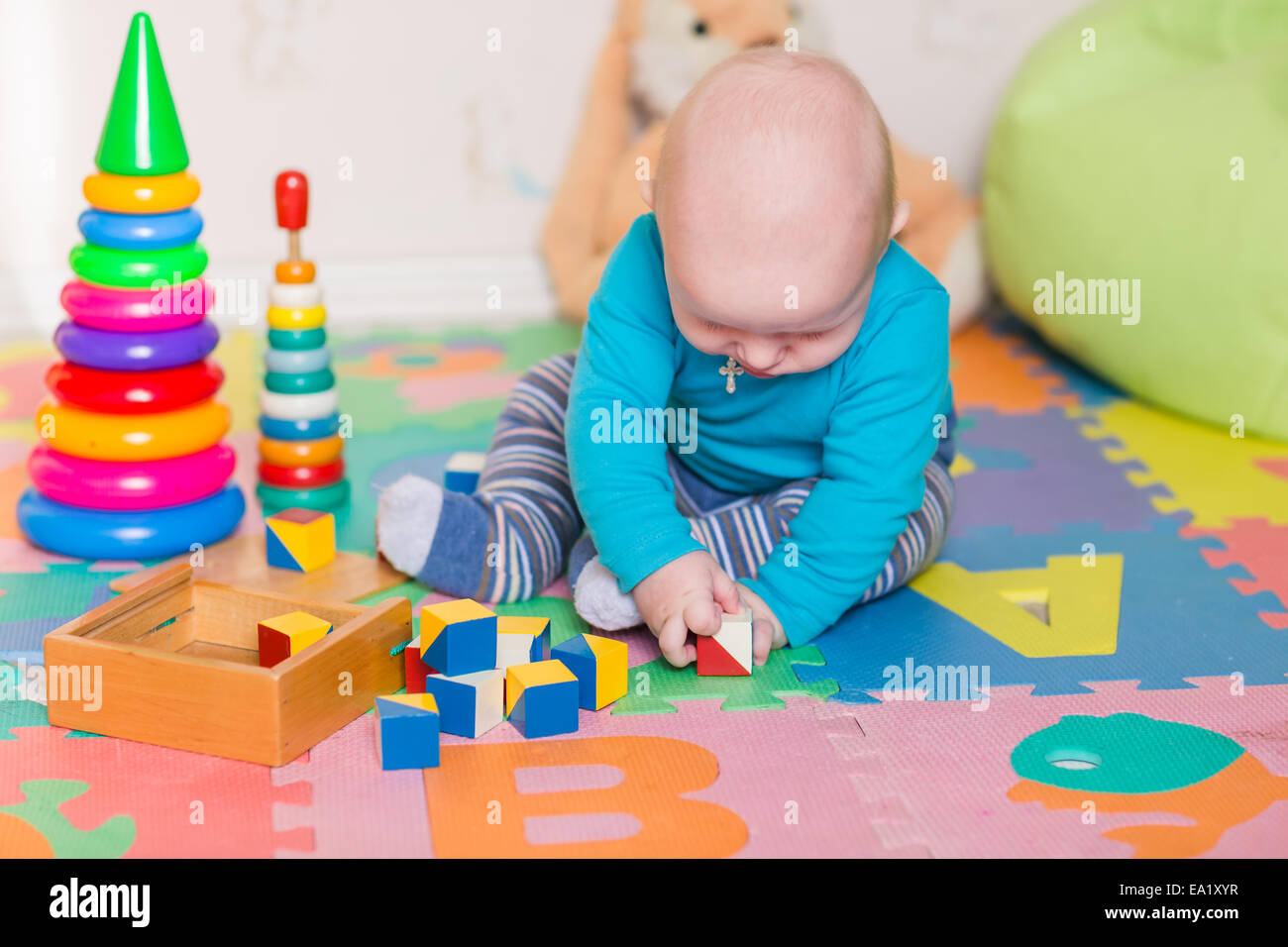 Cute little baby playing with colorful toys at home Stock Photo - Alamy