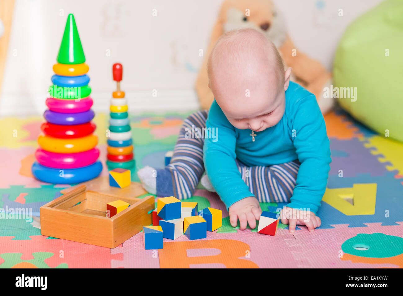 Cute little baby playing with colorful toys at home Stock Photo - Alamy