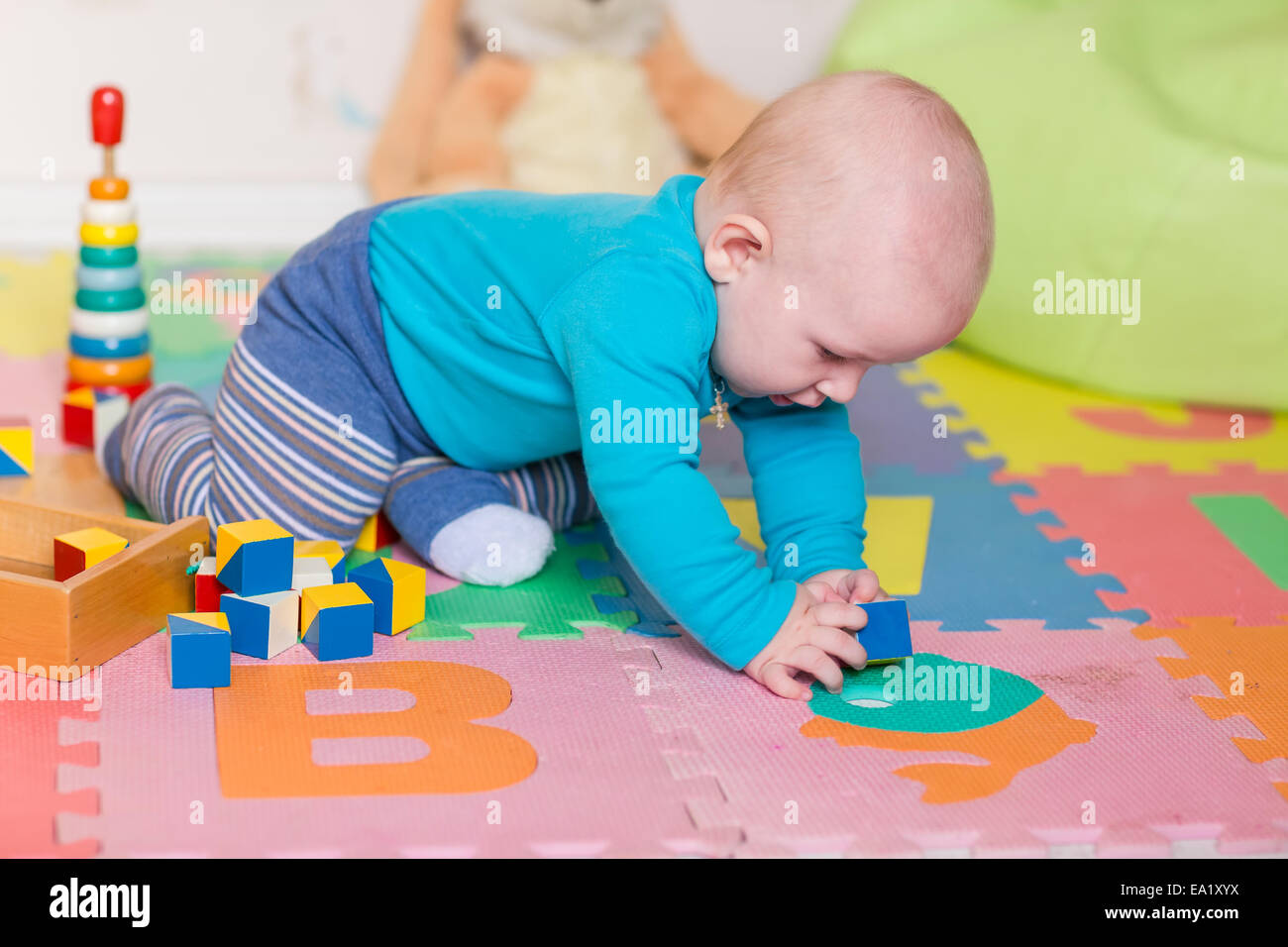 Cute little baby playing with colorful toys at home Stock Photo - Alamy