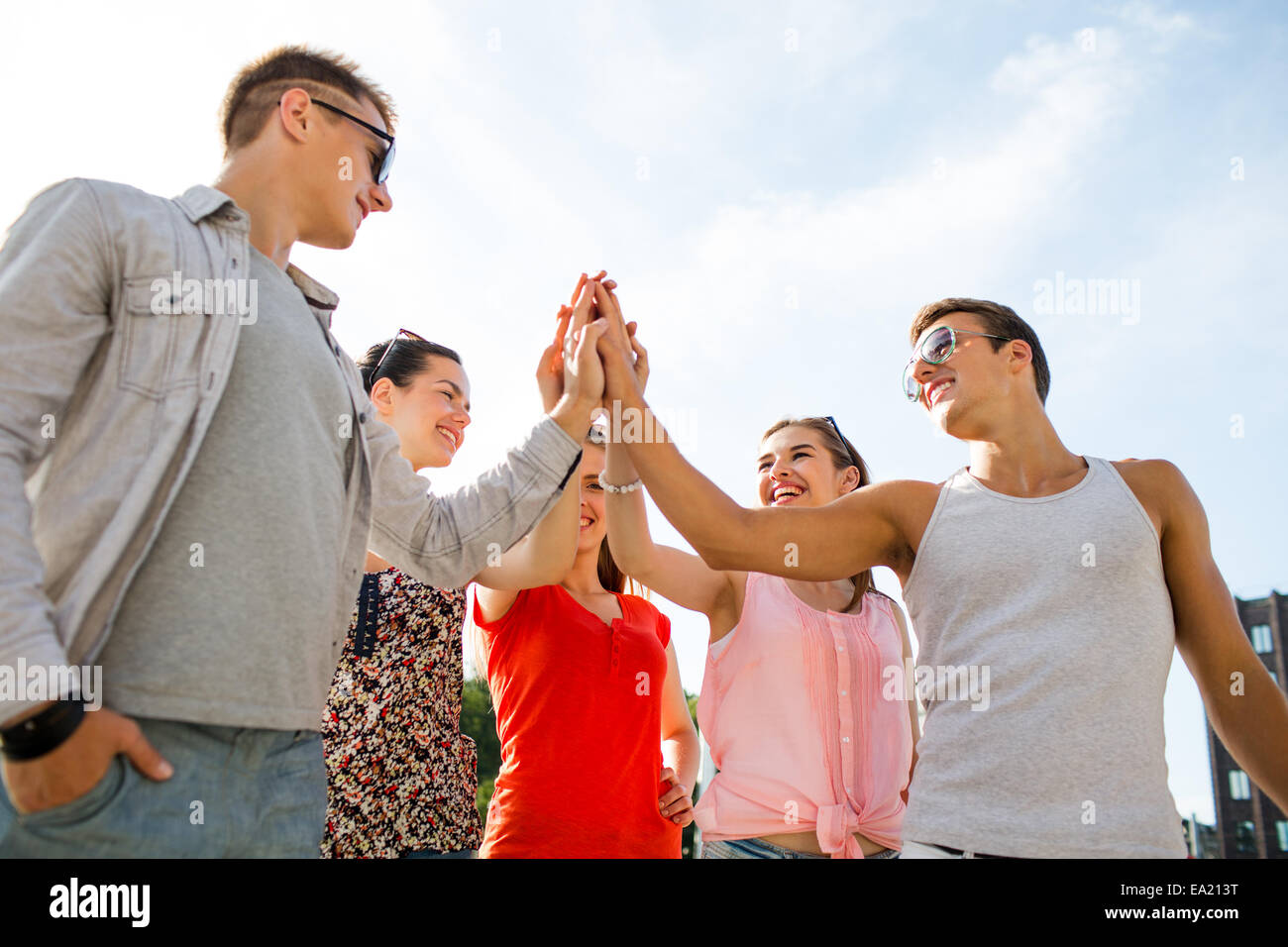 group of smiling friends making high five outdoors Stock Photo - Alamy