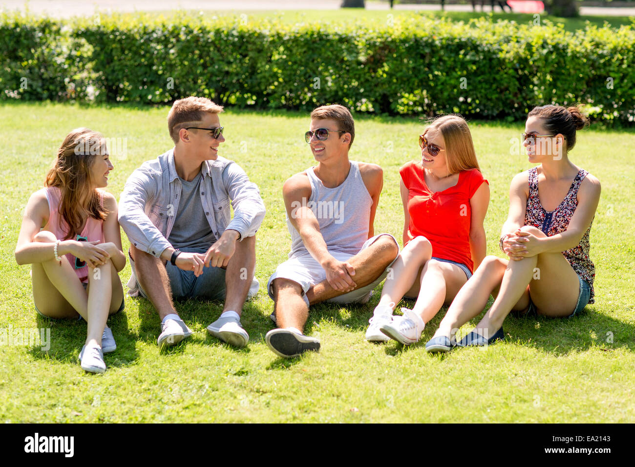 group of smiling friends outdoors sitting on grass Stock Photo - Alamy