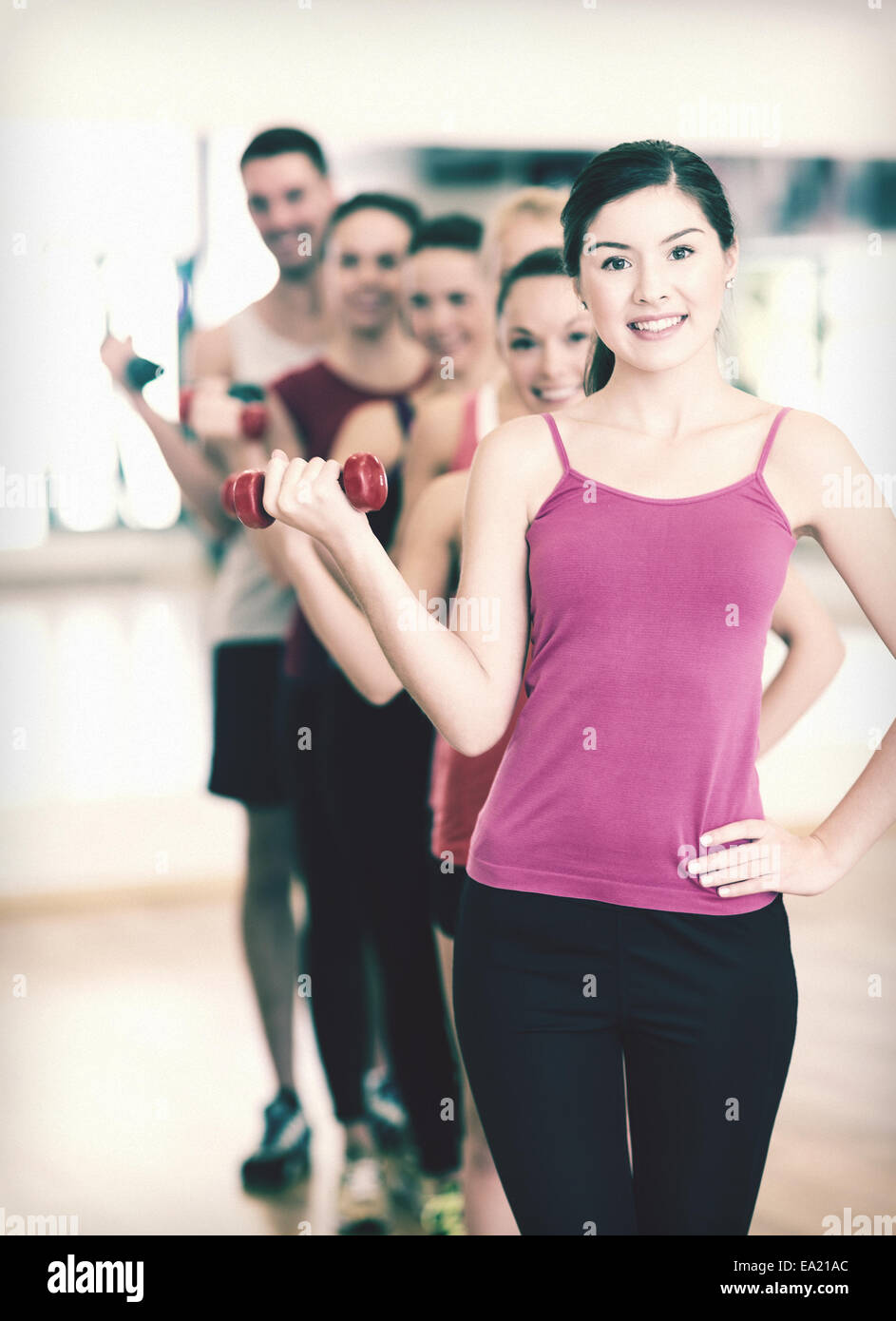 group of smiling people with dumbbells in the gym Stock Photo - Alamy