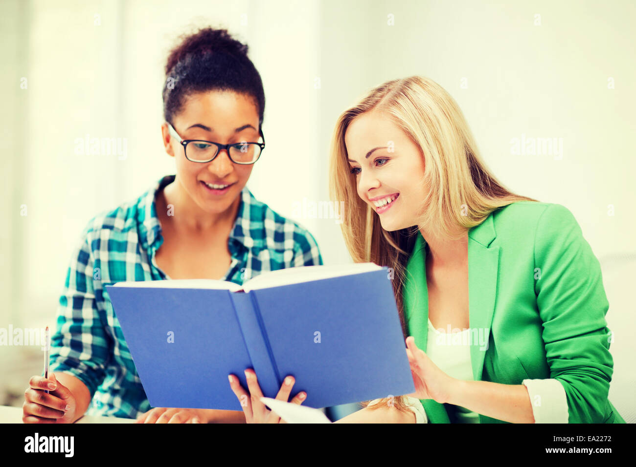 smiling student girls reading book at school Stock Photo - Alamy