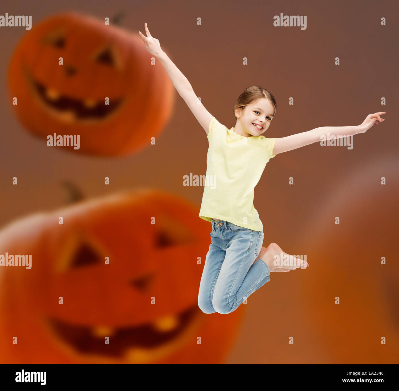smiling girl jumping over pumpkins background Stock Photo - Alamy