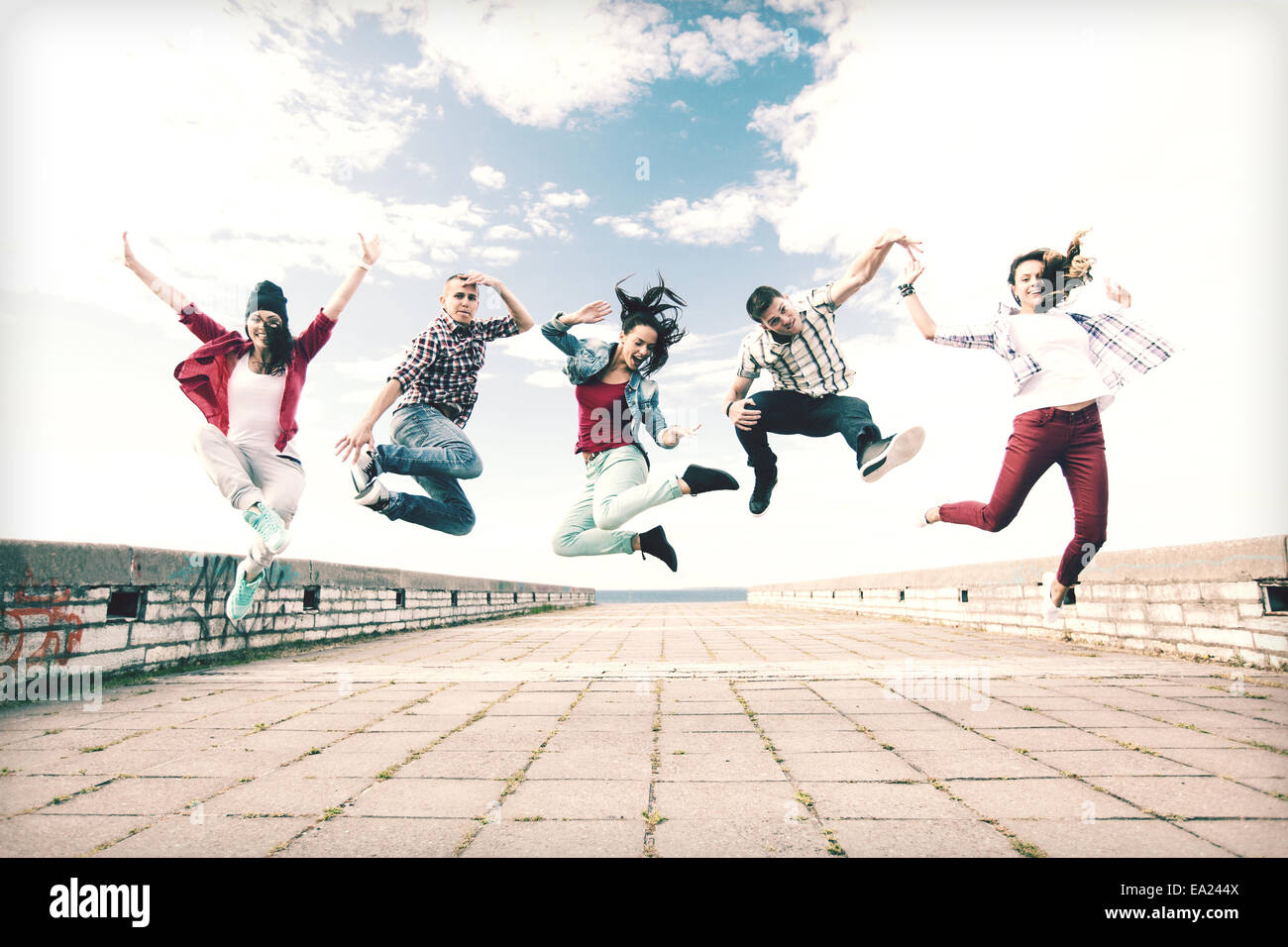 group of teenagers jumping Stock Photo - Alamy