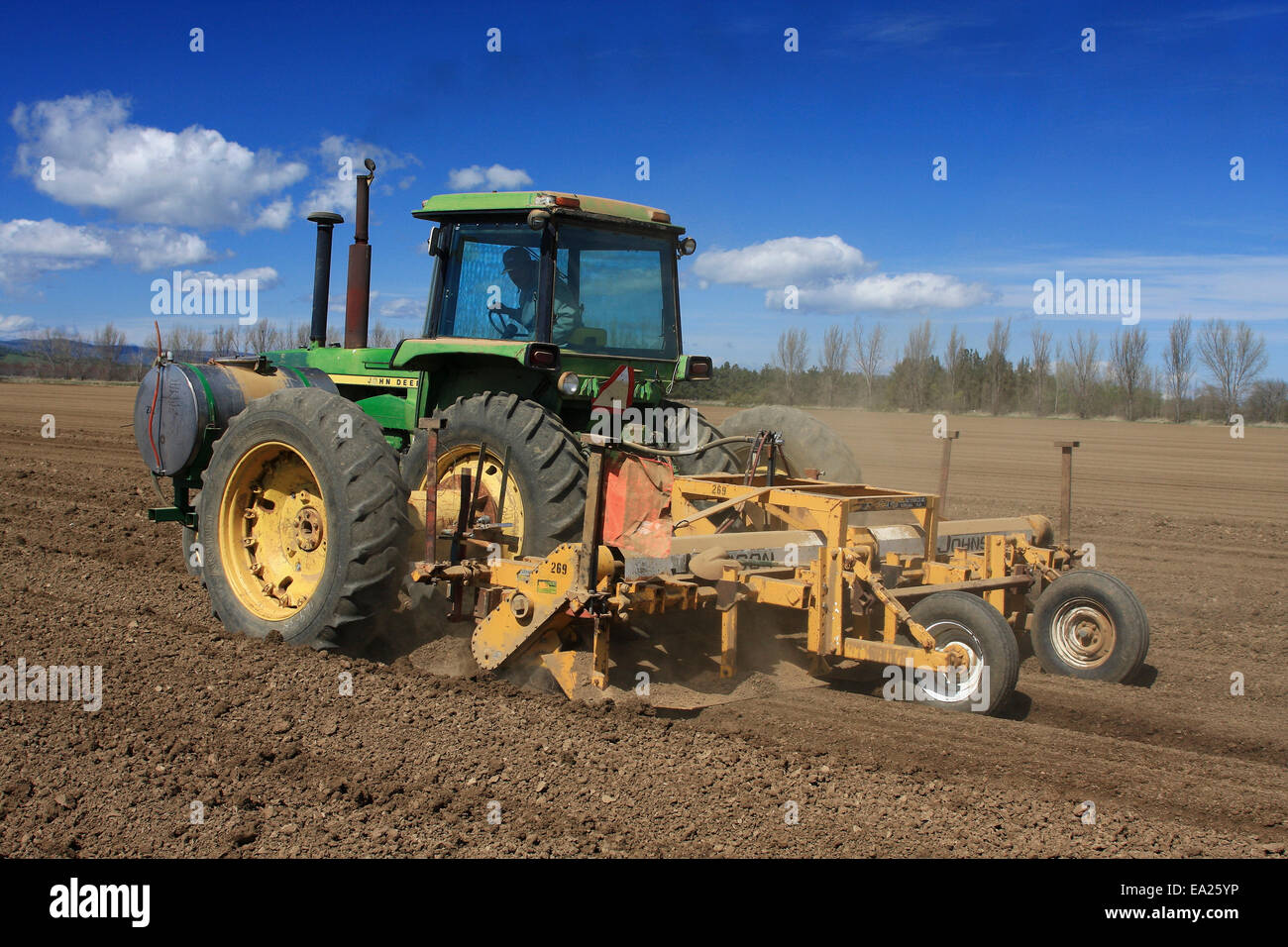 A tractor and incorporator prepare a field by making beds and furrows ...