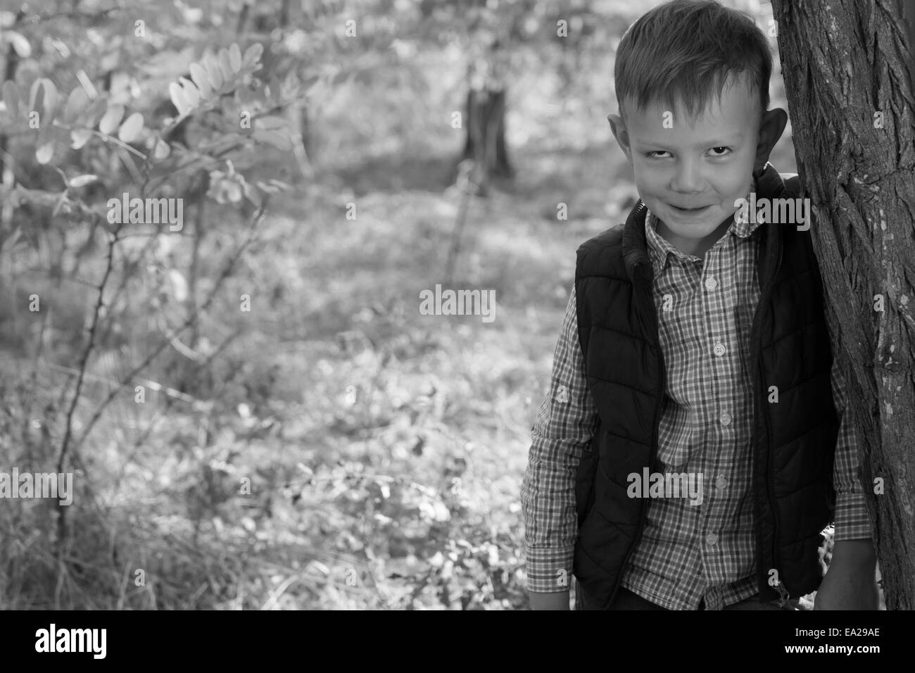 Boy leaning against tree hi-res stock photography and images - Alamy