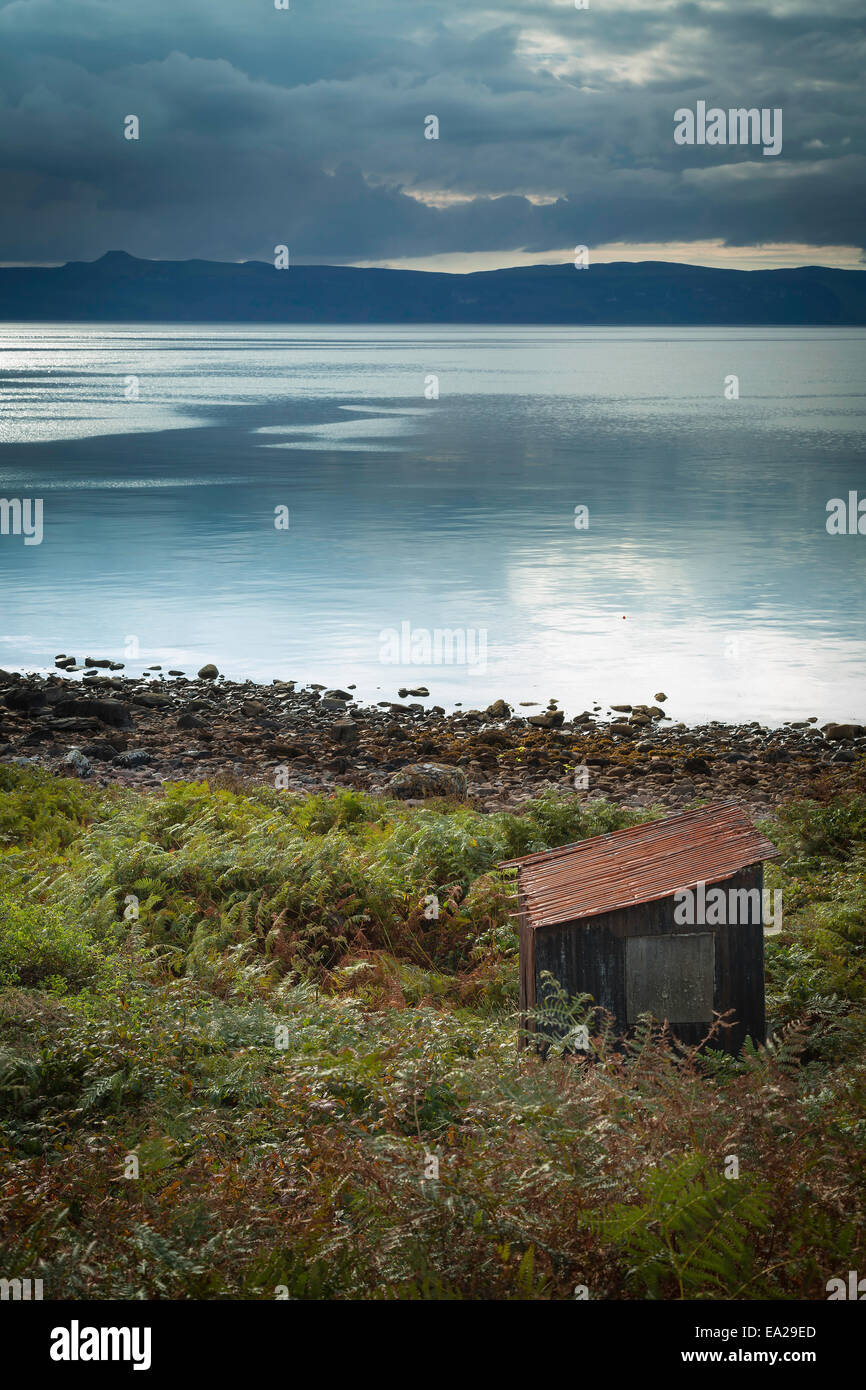 Rusty corrugated iron clad hut on the shore of the Inner Sound ...