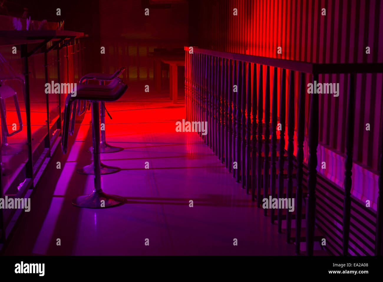 Interior of a nightclub with colorful red and purple lighting and a ...