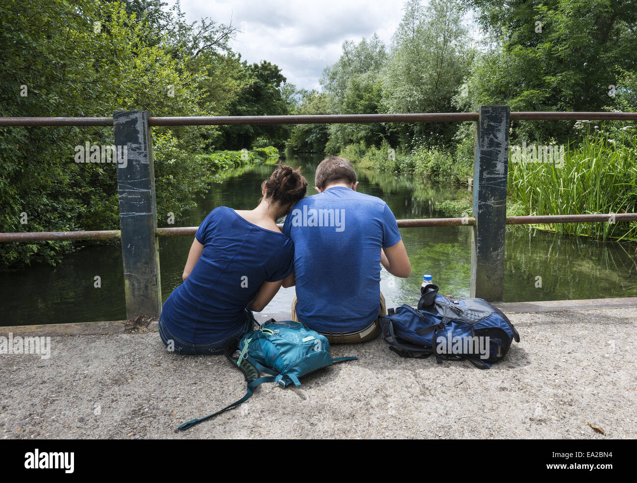 Couple sitting on bridge crossing the River Itchen in Hampshire ...