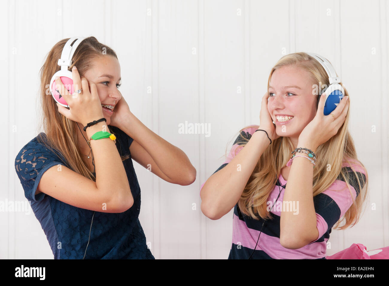 Two teenager girls listening to music with headphones Stock Photo - Alamy