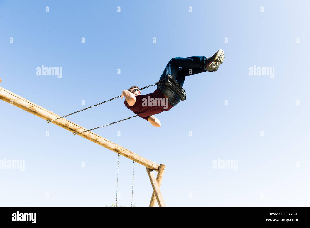 A figure swings on a playground swing Stock Photo - Alamy