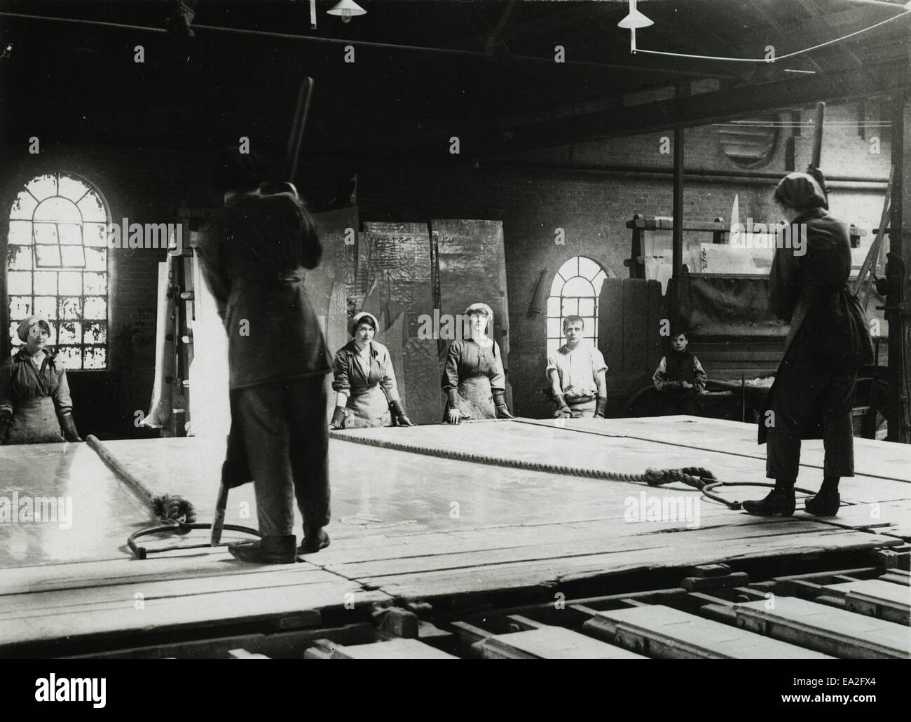 This photograph depicts British women working in glass factories ...