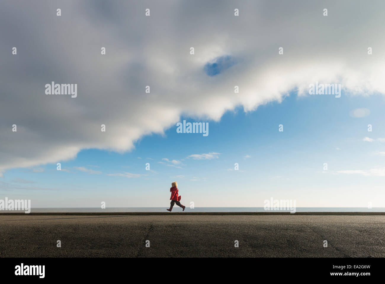 Boy running along sea wall; Aldeburgh, Suffolk, England Stock Photo - Alamy