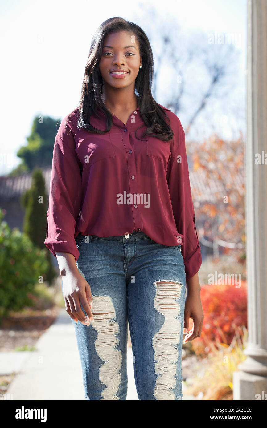 A woman wearing trendy blue jeans walking down the sidewalk; San ...