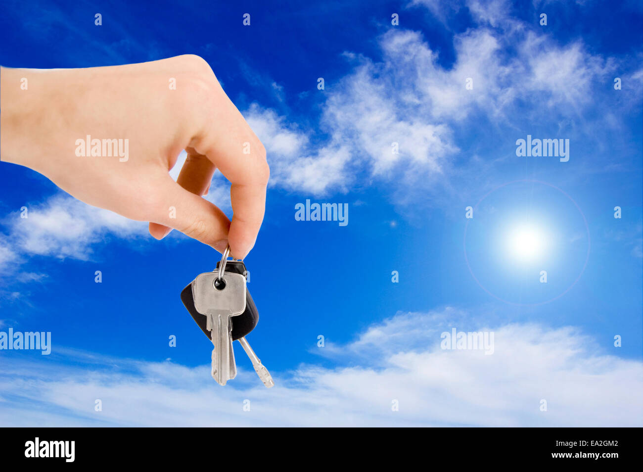 Hand holding keys against blue sky Stock Photo - Alamy