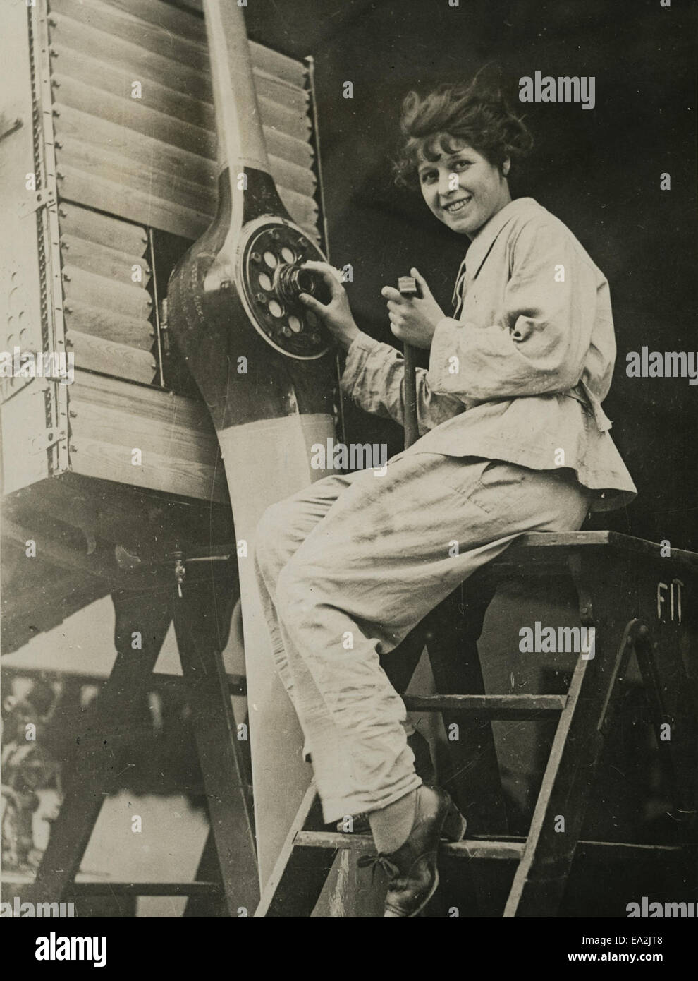 This image illustrates a mechanic working on a World War I biplane ...