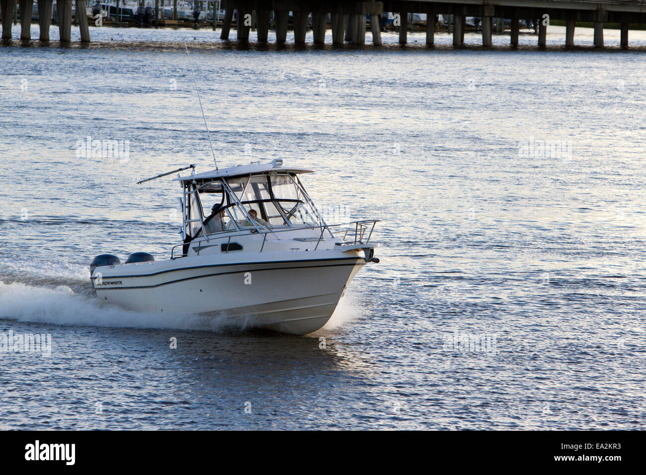 Small powered boat traveling in the water Stock Photo - Alamy