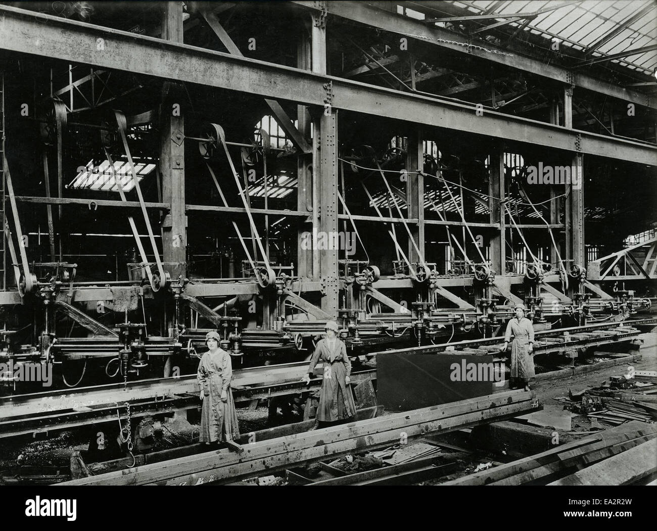 The image depicts women operating radial drilling machines to drill ...