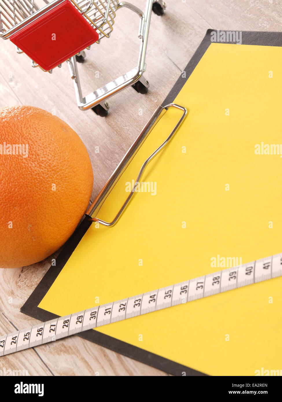 Notepad with a yellow paper and a shopping cart Stock Photo - Alamy