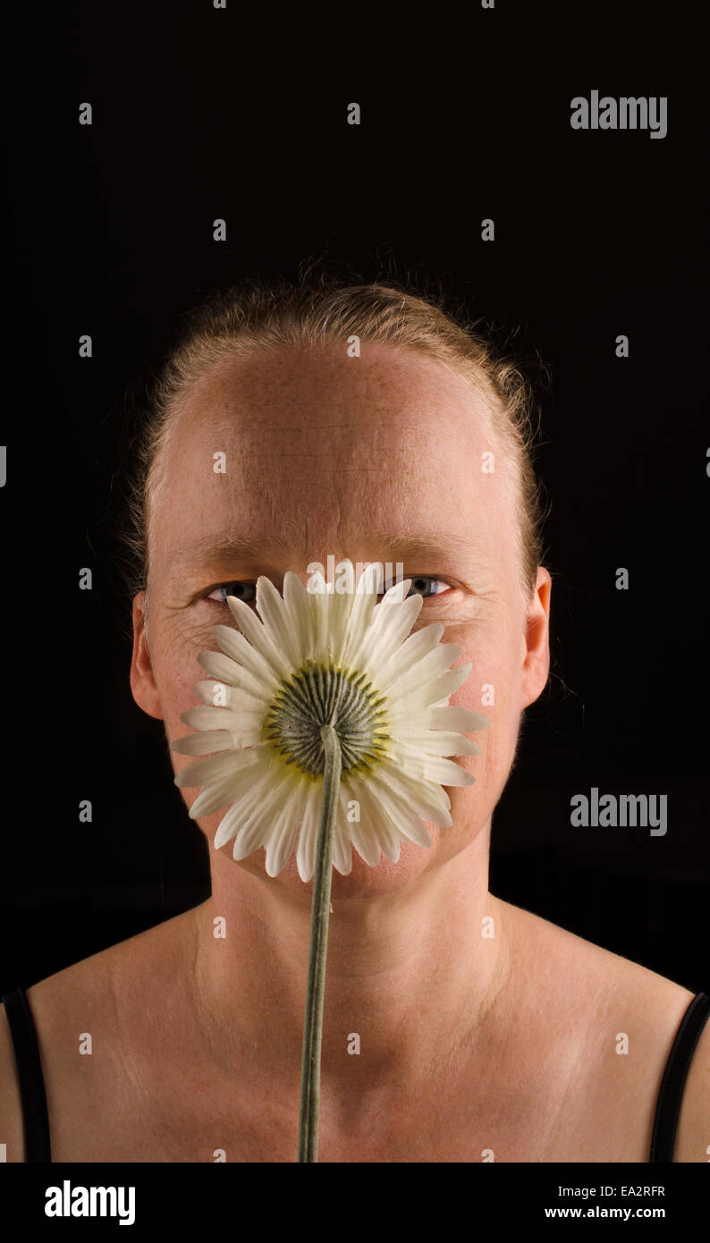 Woman behind a white flower on a dark background Stock Photo - Alamy