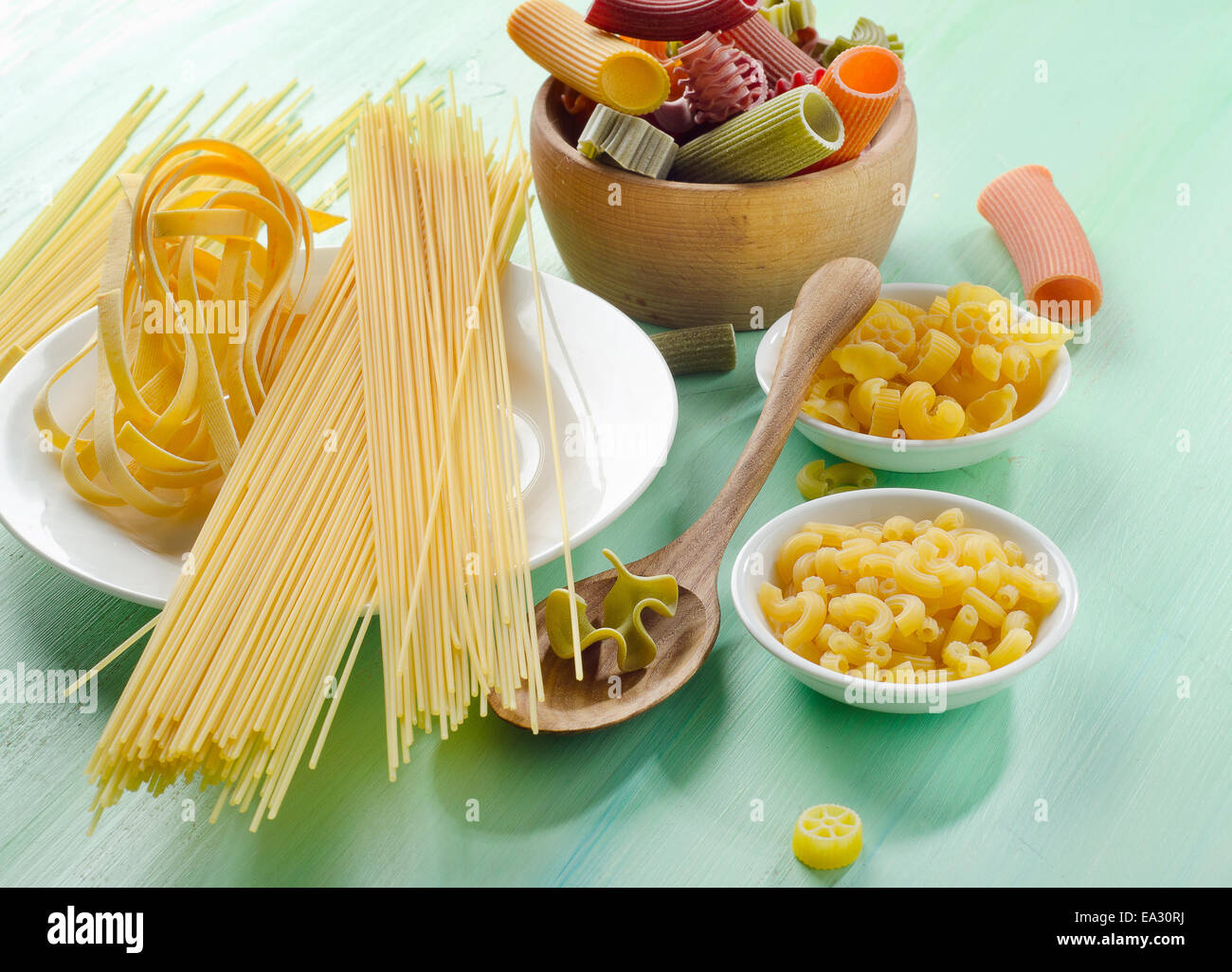 Different types of pasta on a wooden table Stock Photo - Alamy