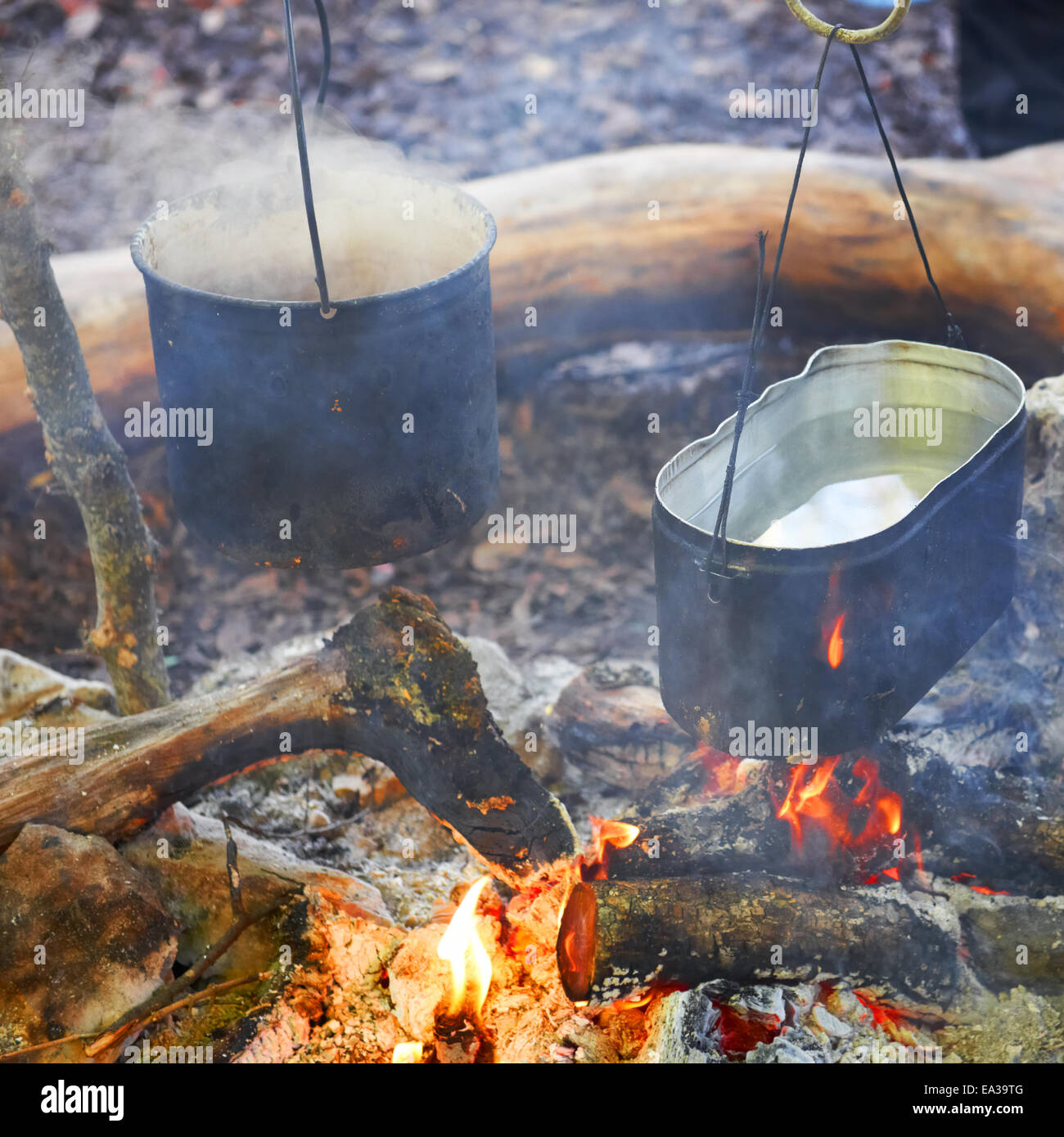 Boiling water in two pots above the fire Stock Photo - Alamy