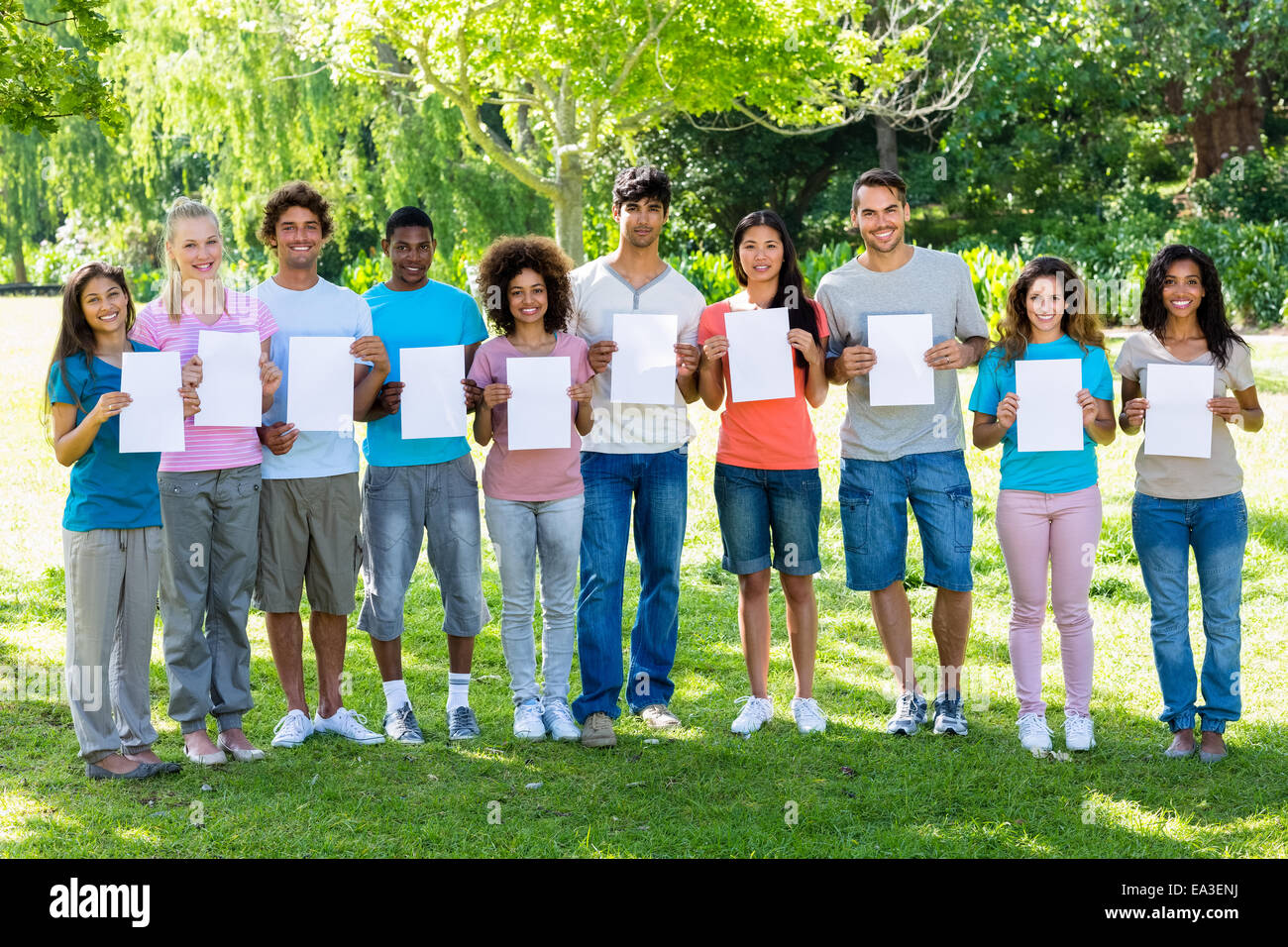 Friends holding blank papers in park Stock Photo - Alamy