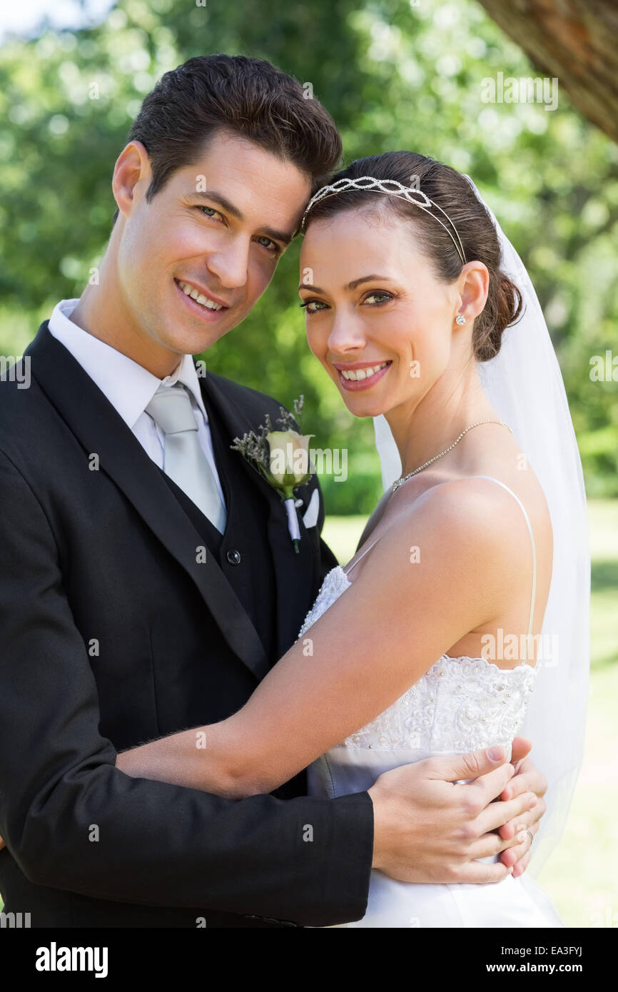 Young bride and groom hugging in garden Stock Photo - Alamy