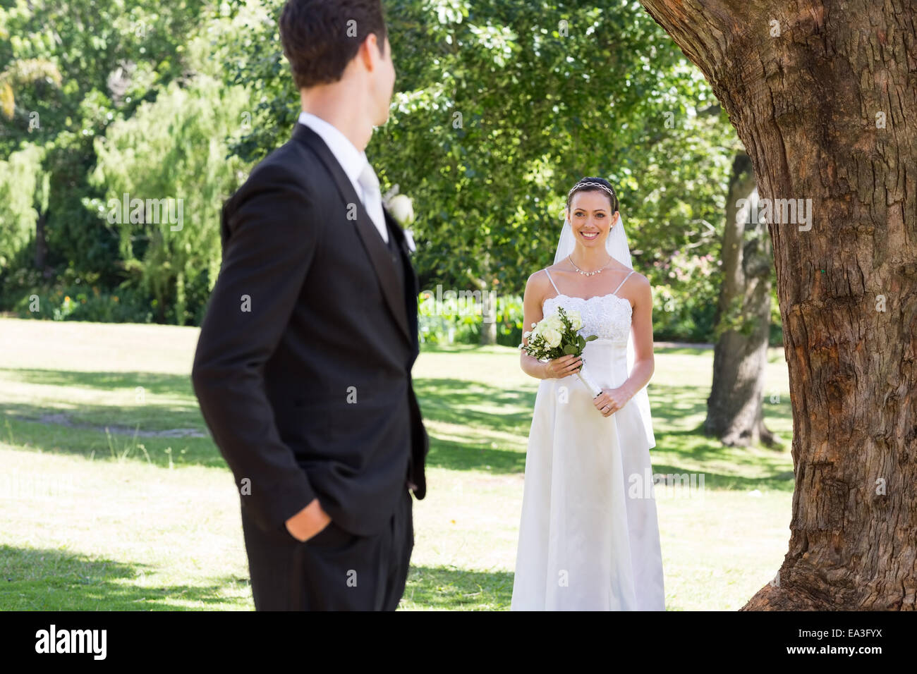 Bride looking at groom in garden Stock Photo - Alamy