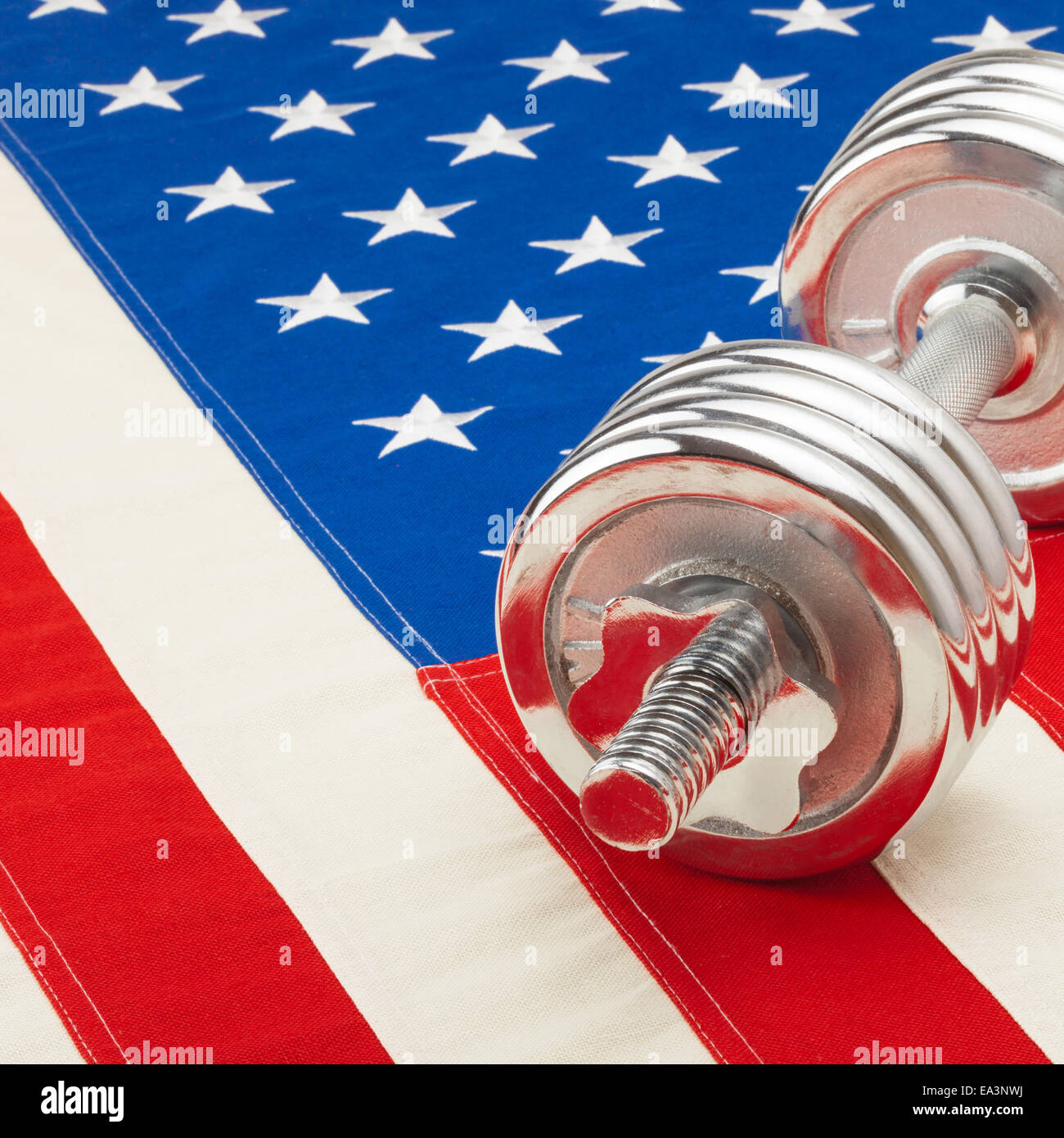 Metal dumbbell over US flag as symbol of bodybuilding - studio shot ...