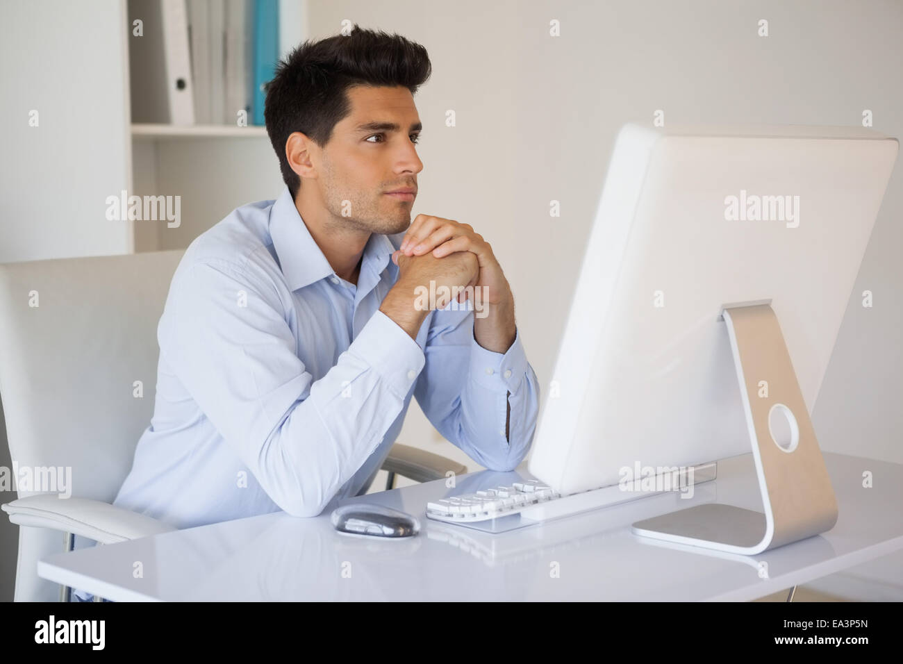 Casual businessman concentrating at his desk Stock Photo - Alamy