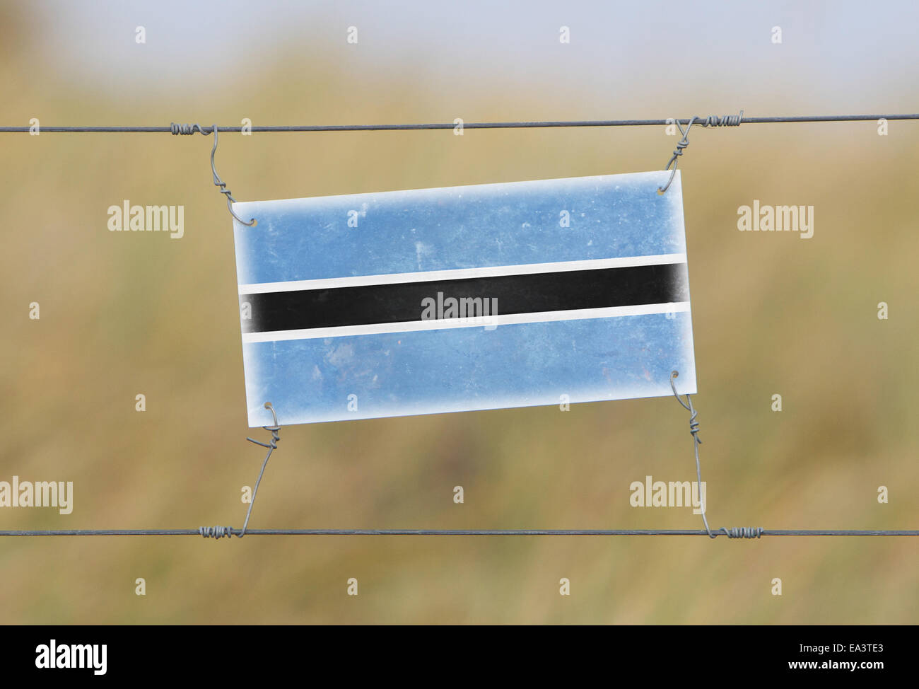 Border fence - Old plastic sign with a flag - Botswana Stock Photo - Alamy