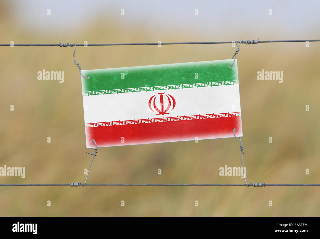Border fence - Old plastic sign with a flag - Iran Stock Photo - Alamy