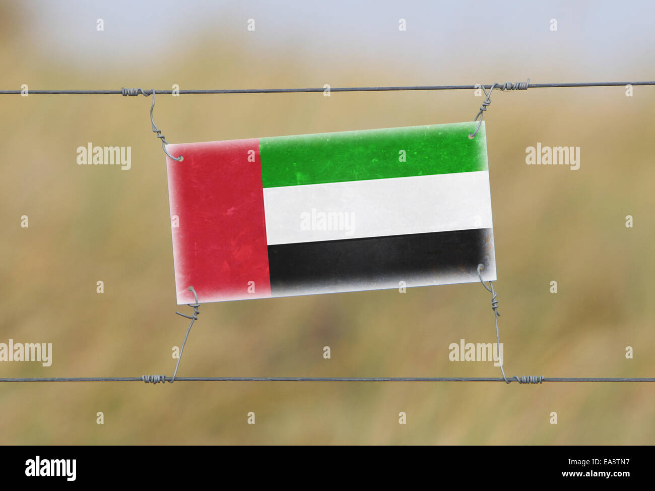 Border fence - Old plastic sign with a flag - United Arab Emirates ...