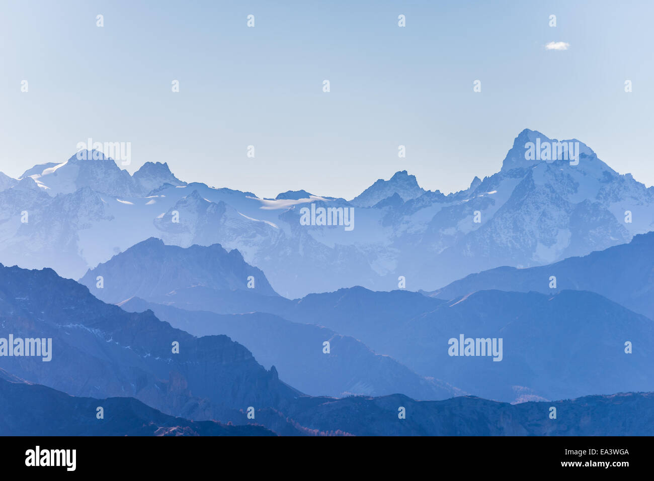 Distant blue toned mountain range of the majestic Ecrins Massif ...