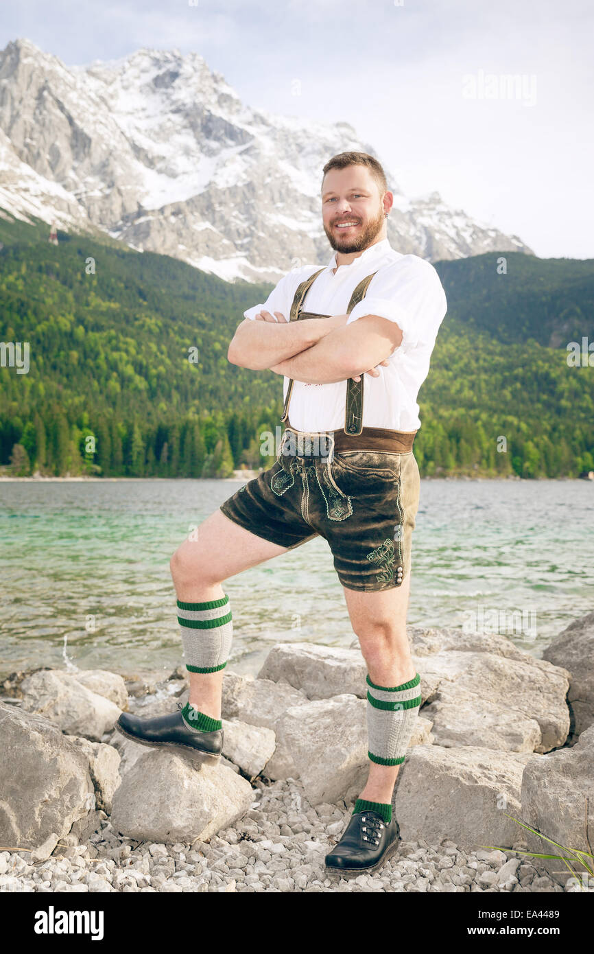 A traditional bavarian man at lake Eibsee with the Zugspitze mountain ...